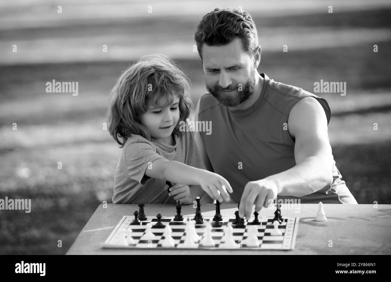 Father and son playing chess spending time together outdoor. Kid play ...