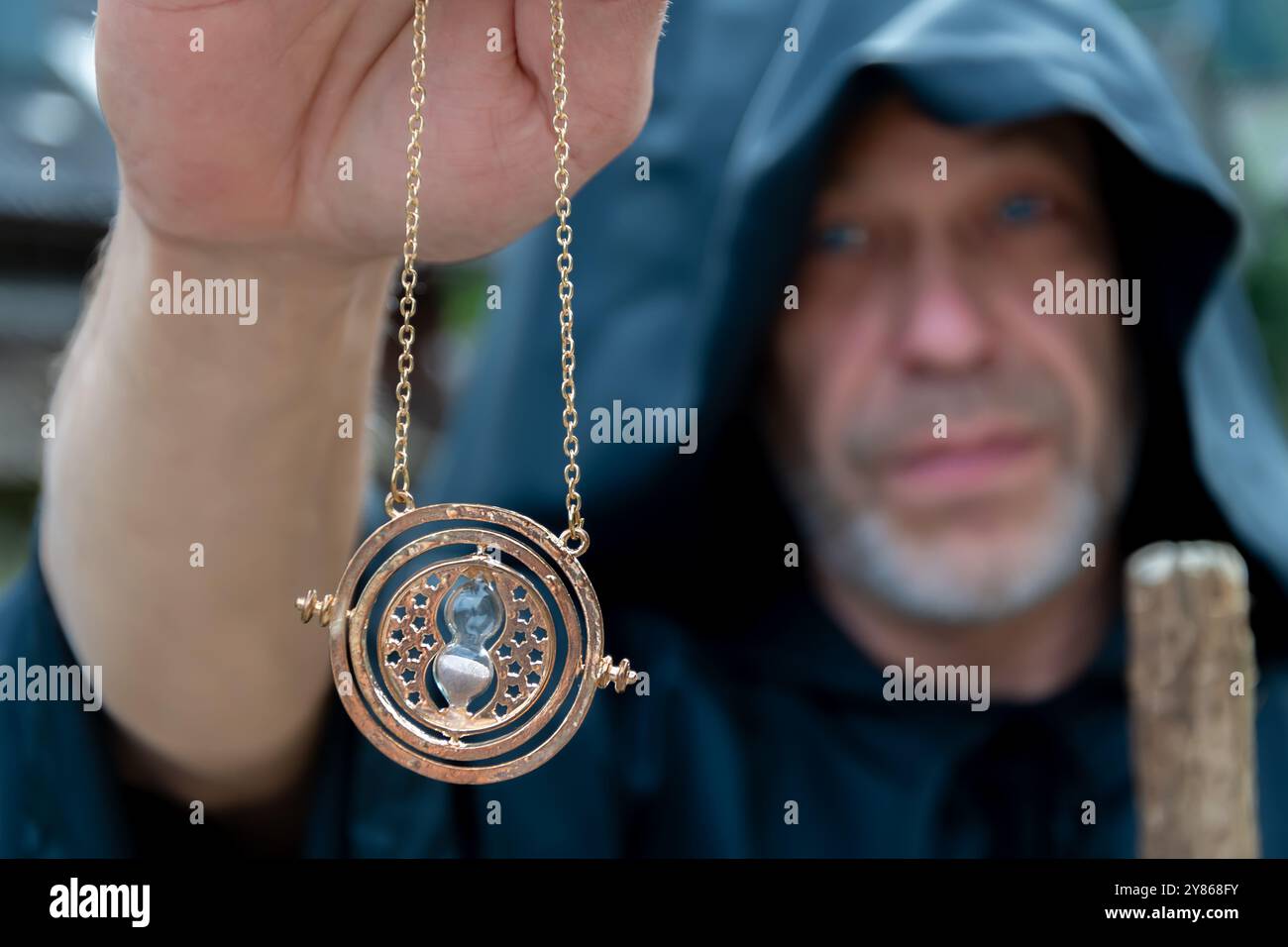 An old monk with a beard holds an hourglass amulet in his hand Stock ...