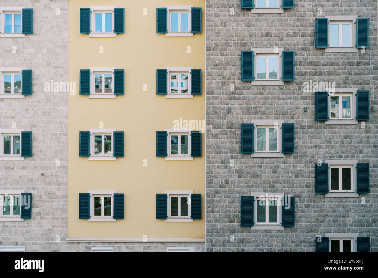 Multi-colored facades of apartment buildings with green shutters on ...