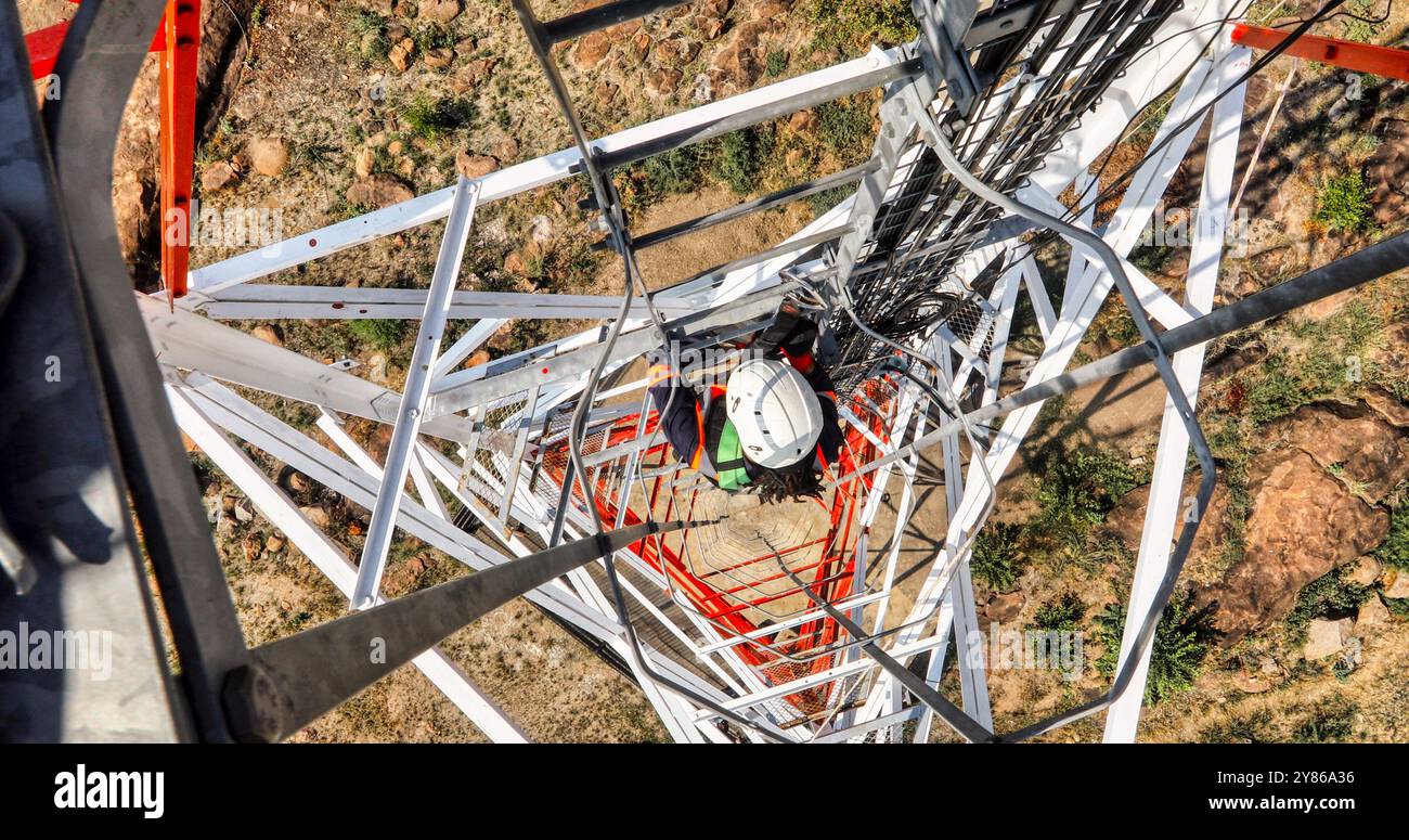 Aerial view, technician climbing on a communication tower to repair an ...