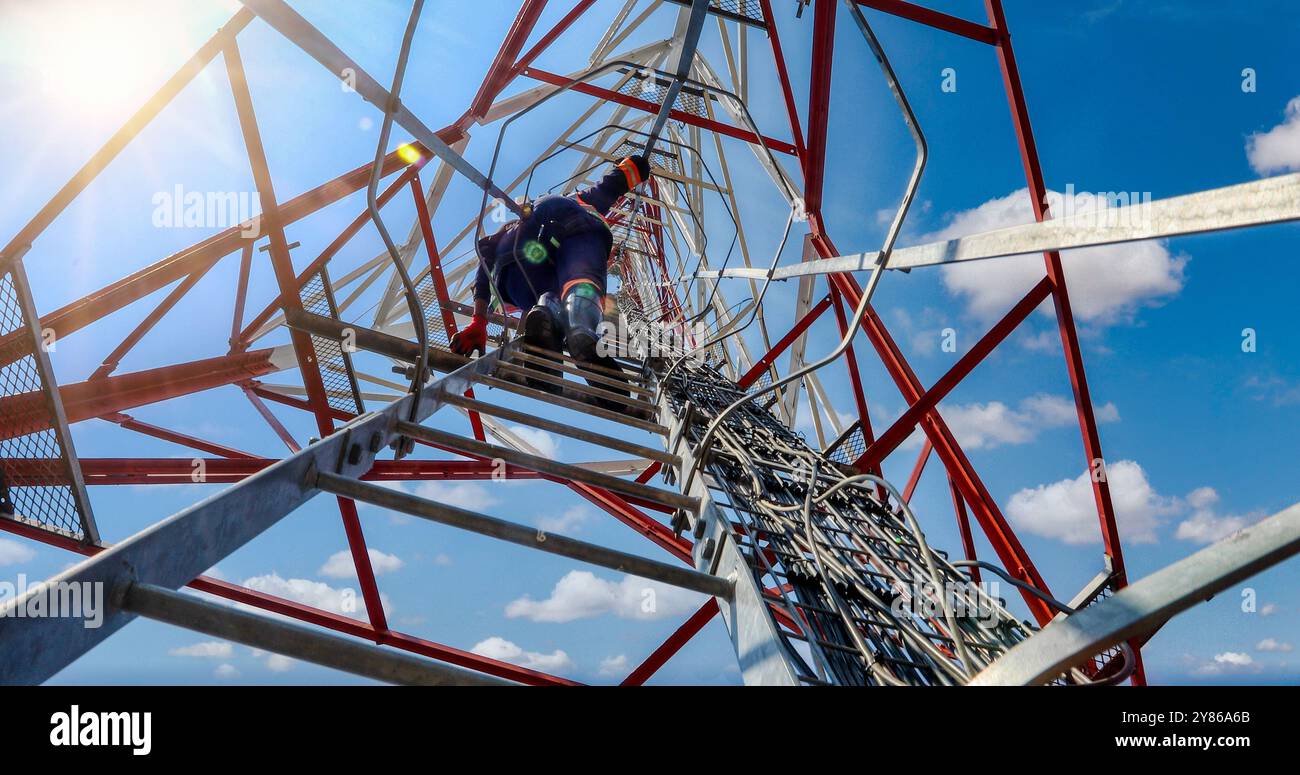 Aerial view, technician climbing on a communication tower to repair an ...