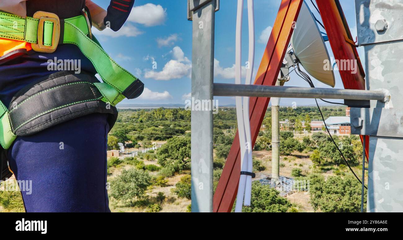 Aerial view technician on a communication tower repairing an antenna ...