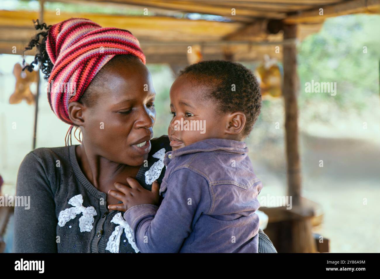 village african mother and child portrait , poverty shack background ...