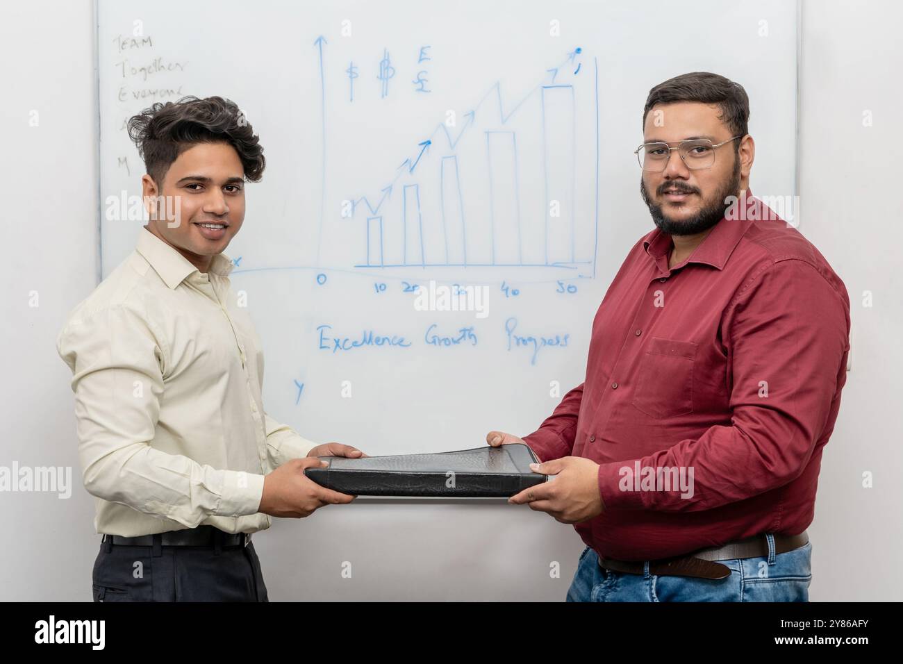 Two business partners are depicted sharing a file folder after signing ...