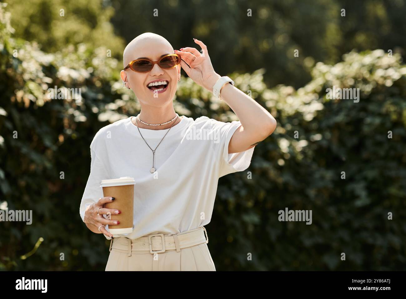 A young bald woman beams with joy while sipping coffee in elegant ...