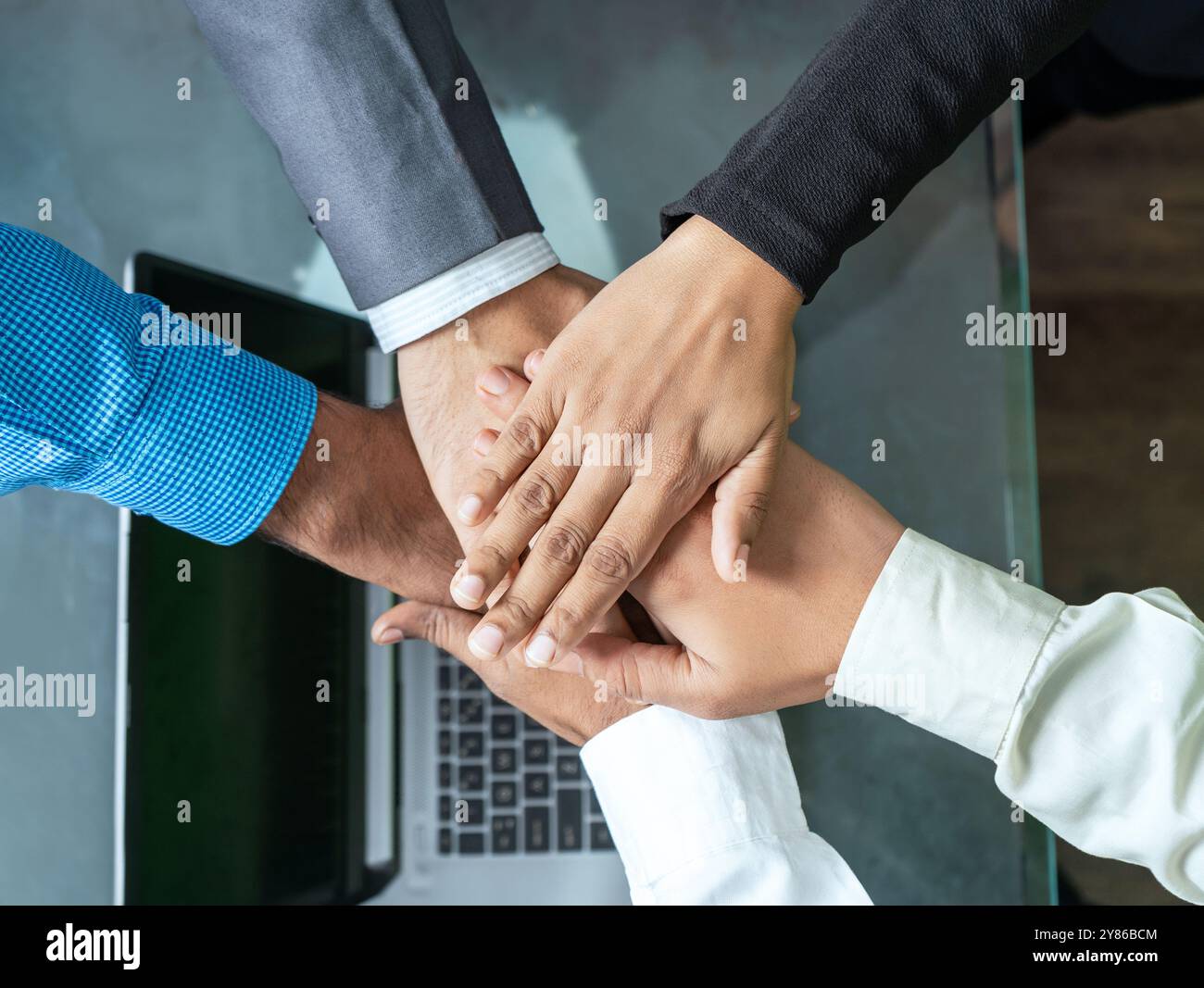 A close-up view of diverse, multiethnic employees stacking their hands ...