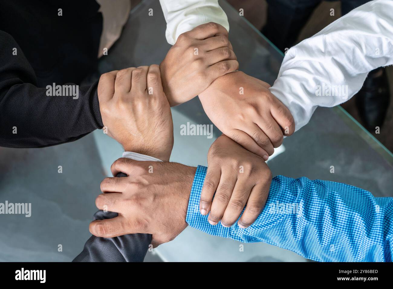 A diverse group of businessmen and women working together in a top-view ...