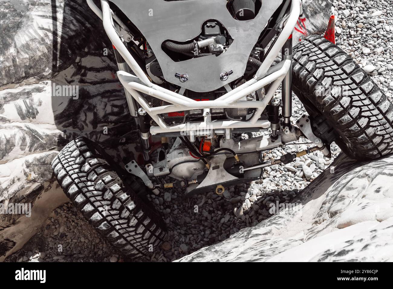 Powerful off-road buggy is tackling a difficult rock obstacle during a ...