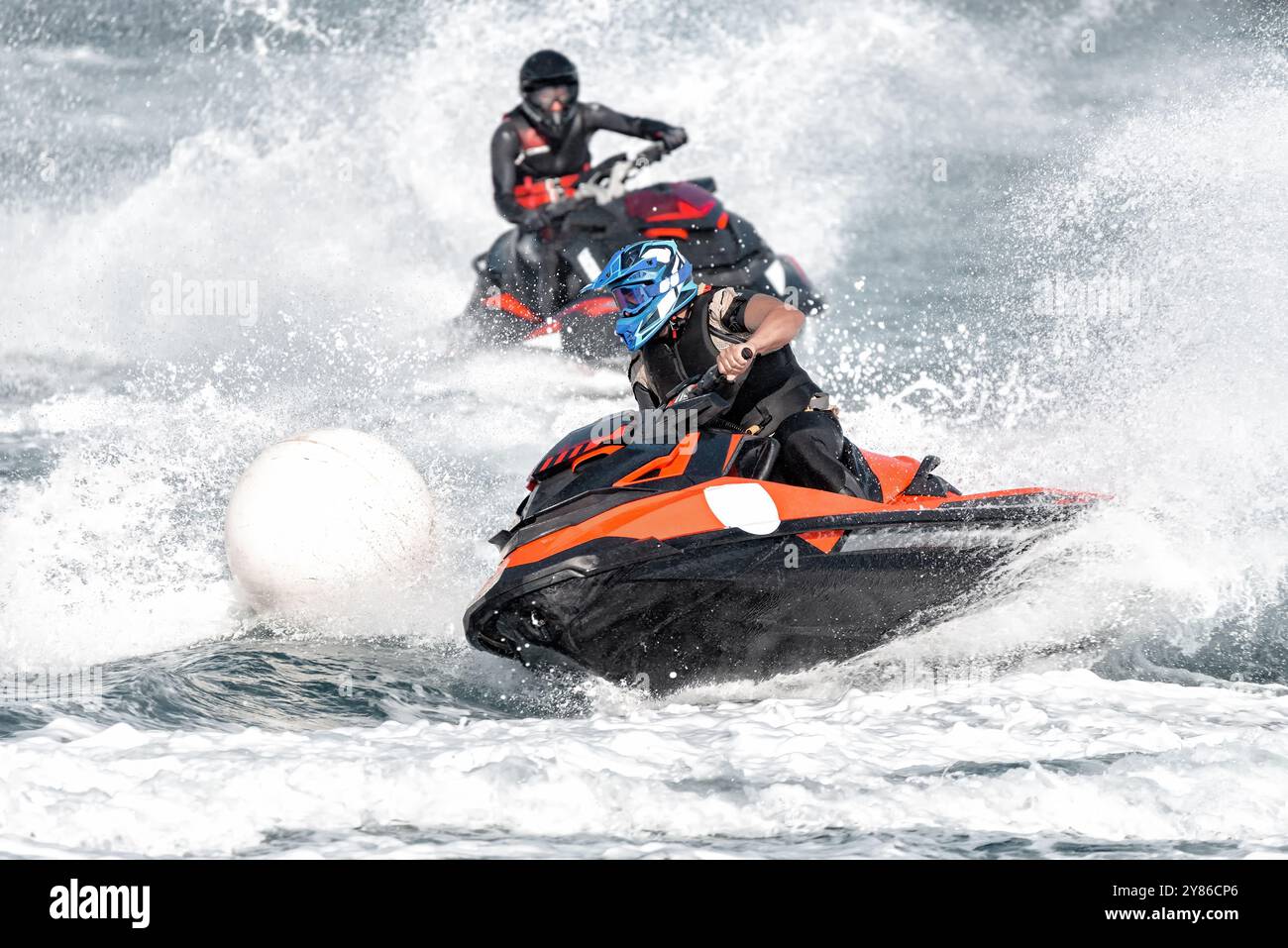 Professional athlete on a jet ski is turning sharply around a buoy ...
