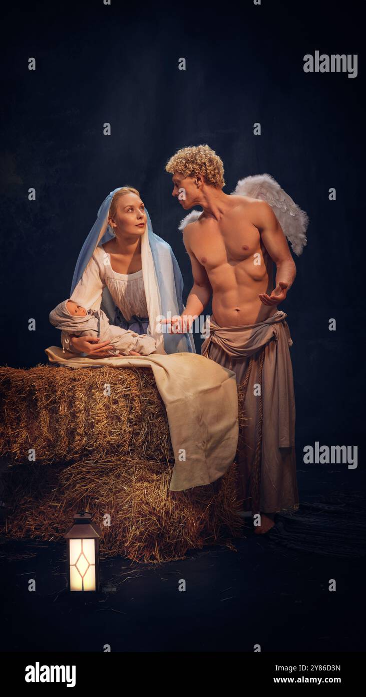 Christmas nativity scene with Mary holding baby Jesus and angel ...