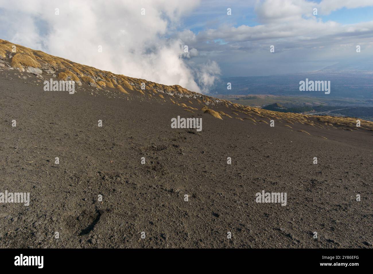 Footprints in ash of the volcanic landscape of Mount Etna with black ...