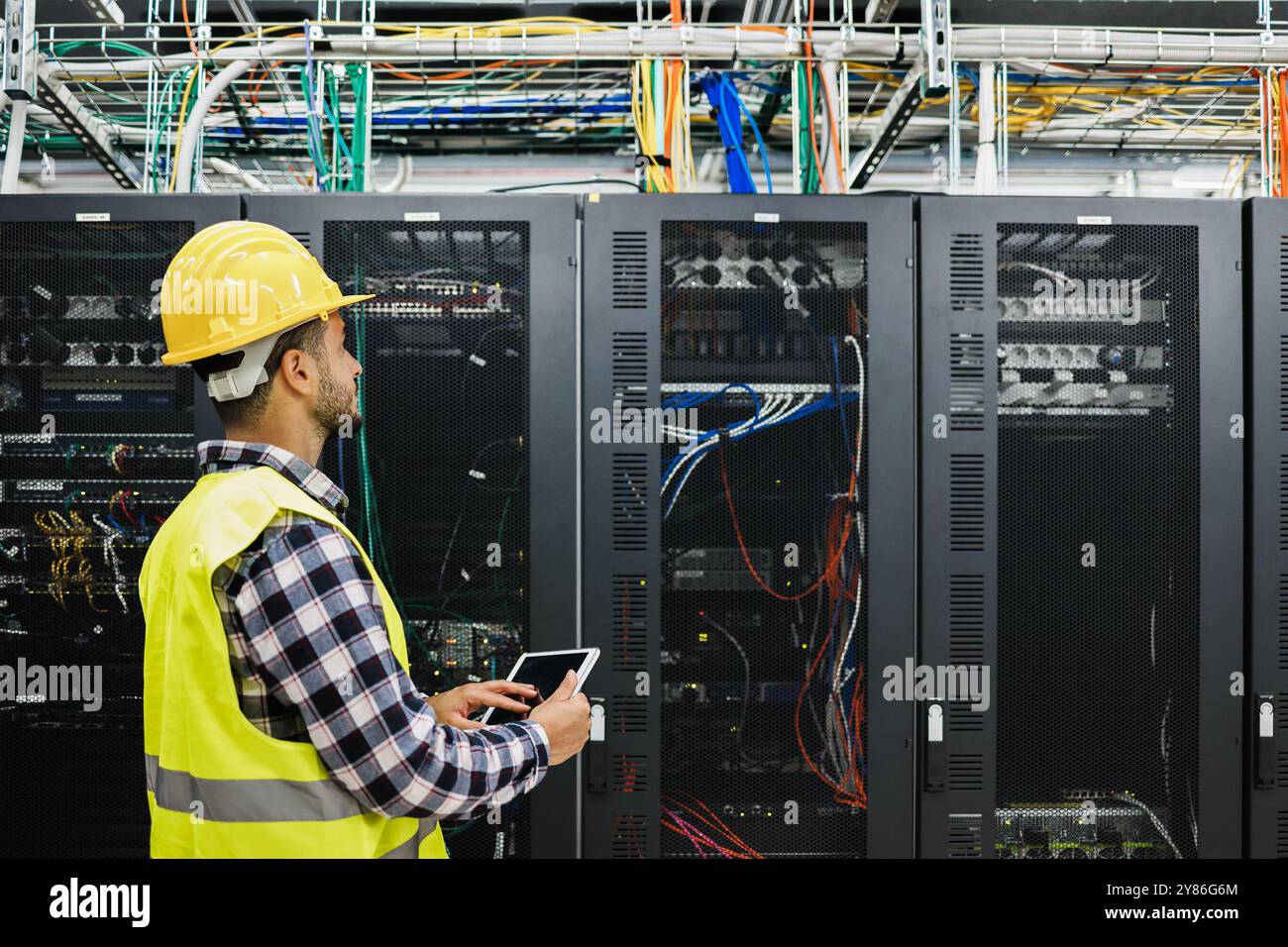 Young technician man working inside big data center room - Technology ...