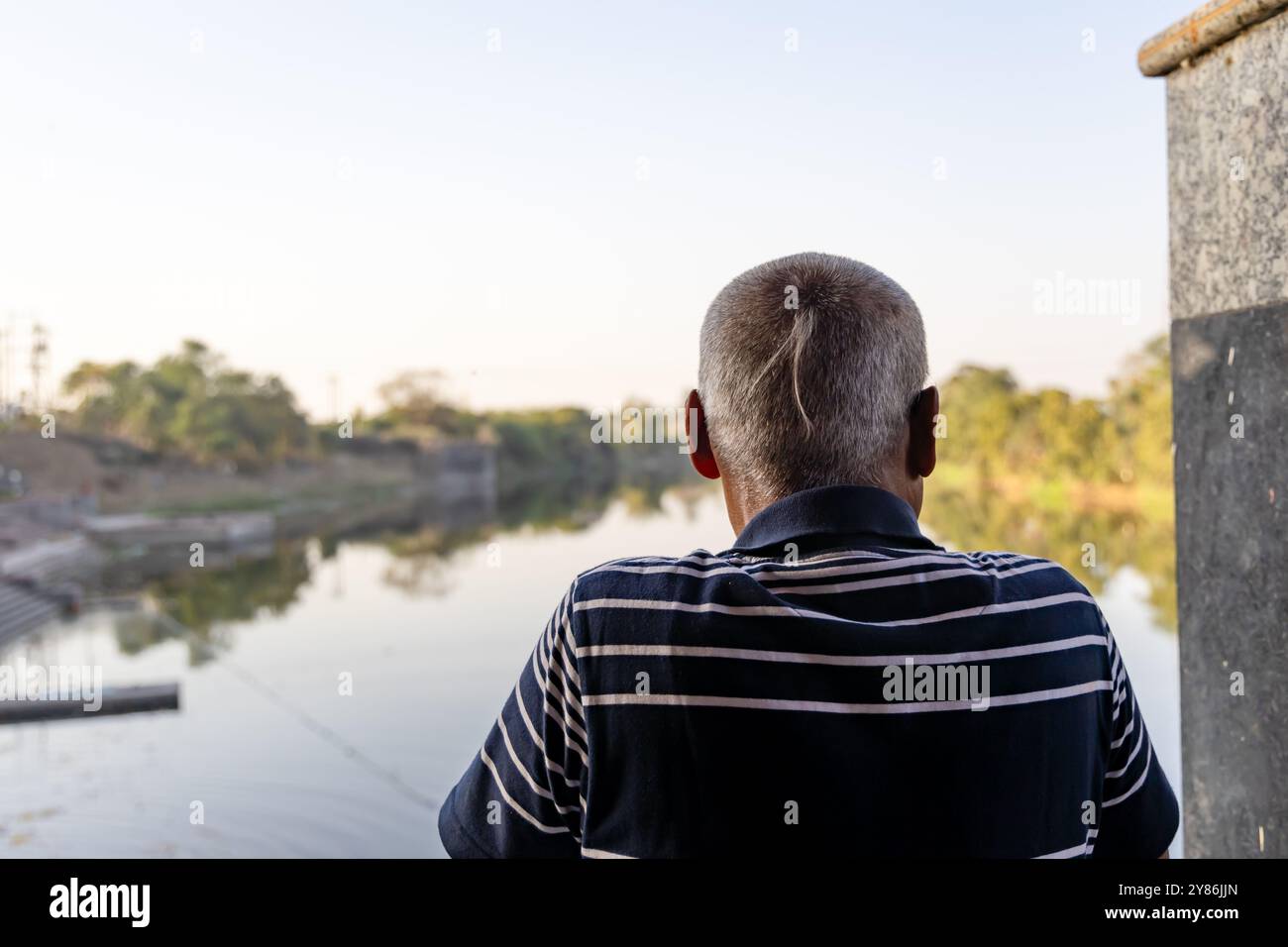 hindu devotee looking out the holy river shore at day from back Stock ...