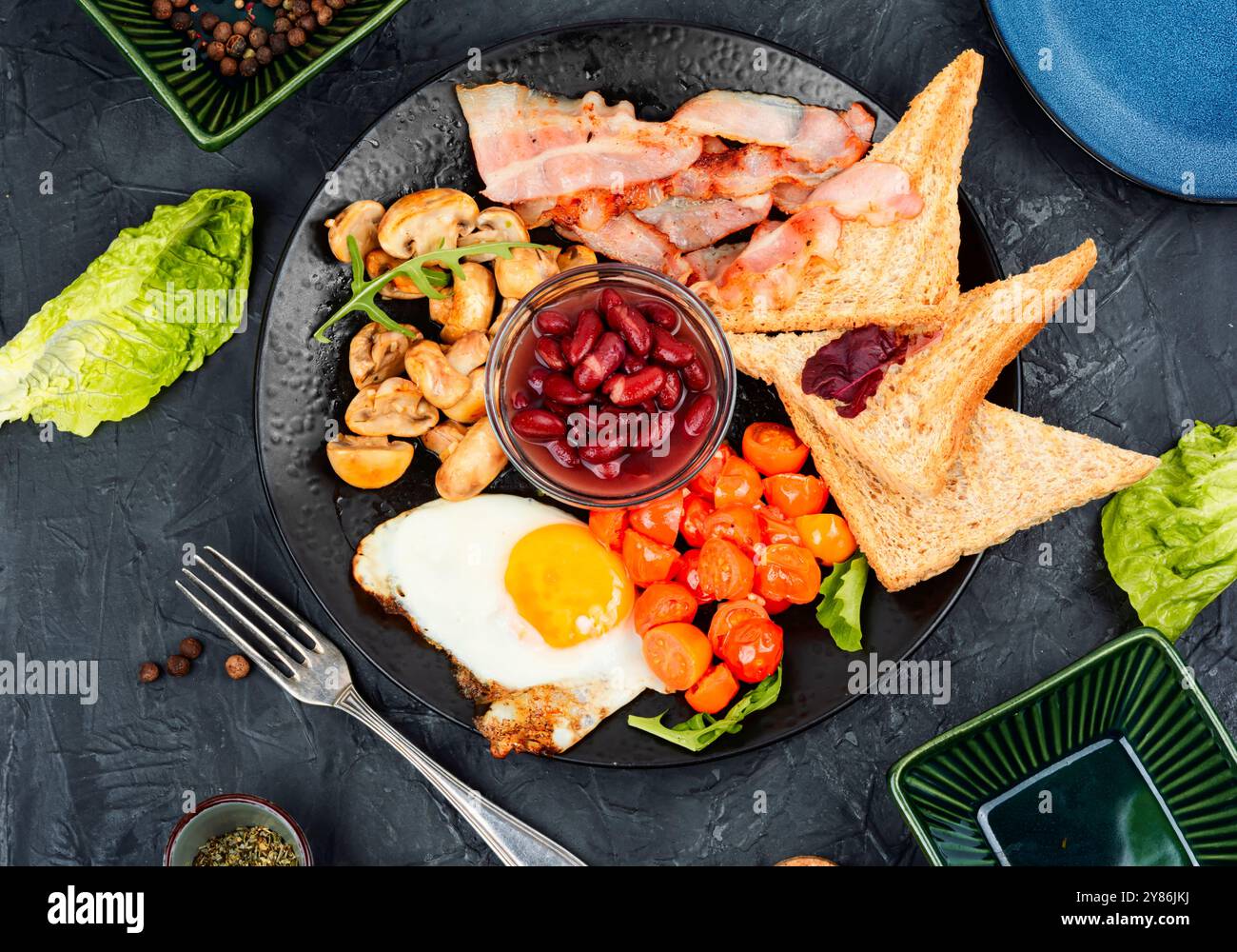 Fried bacon and eggs, toast and beans and vegetables. Traditional ...