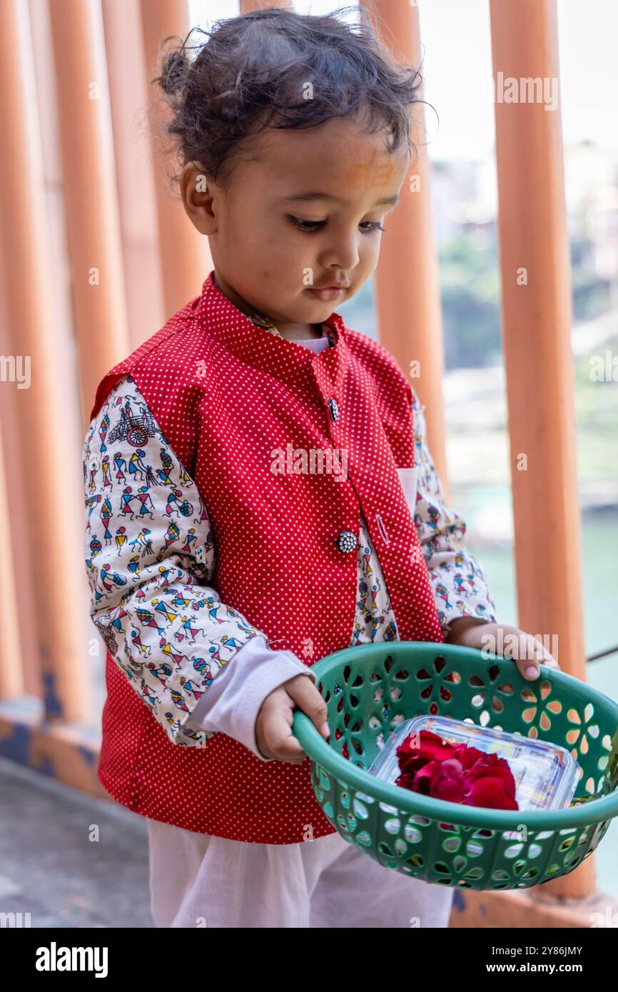 isolated cute kid devotee with holy offering at temple in indian ...