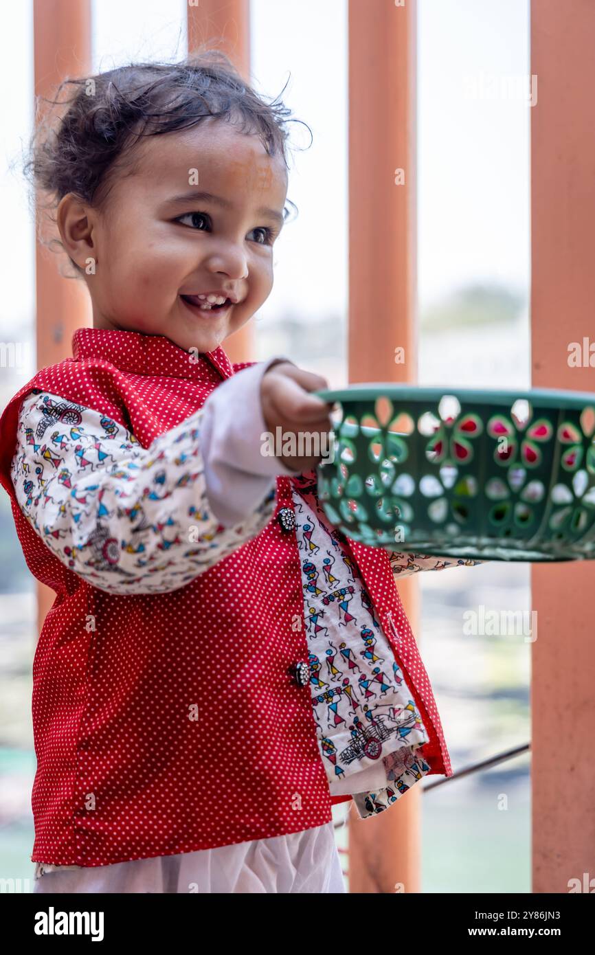 isolated cute kid devotee with holy offering at temple in indian ...