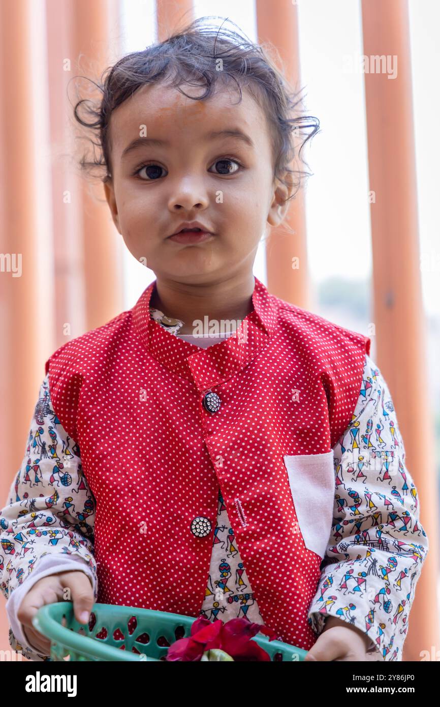 isolated cute kid devotee with holy offering at temple in indian ...