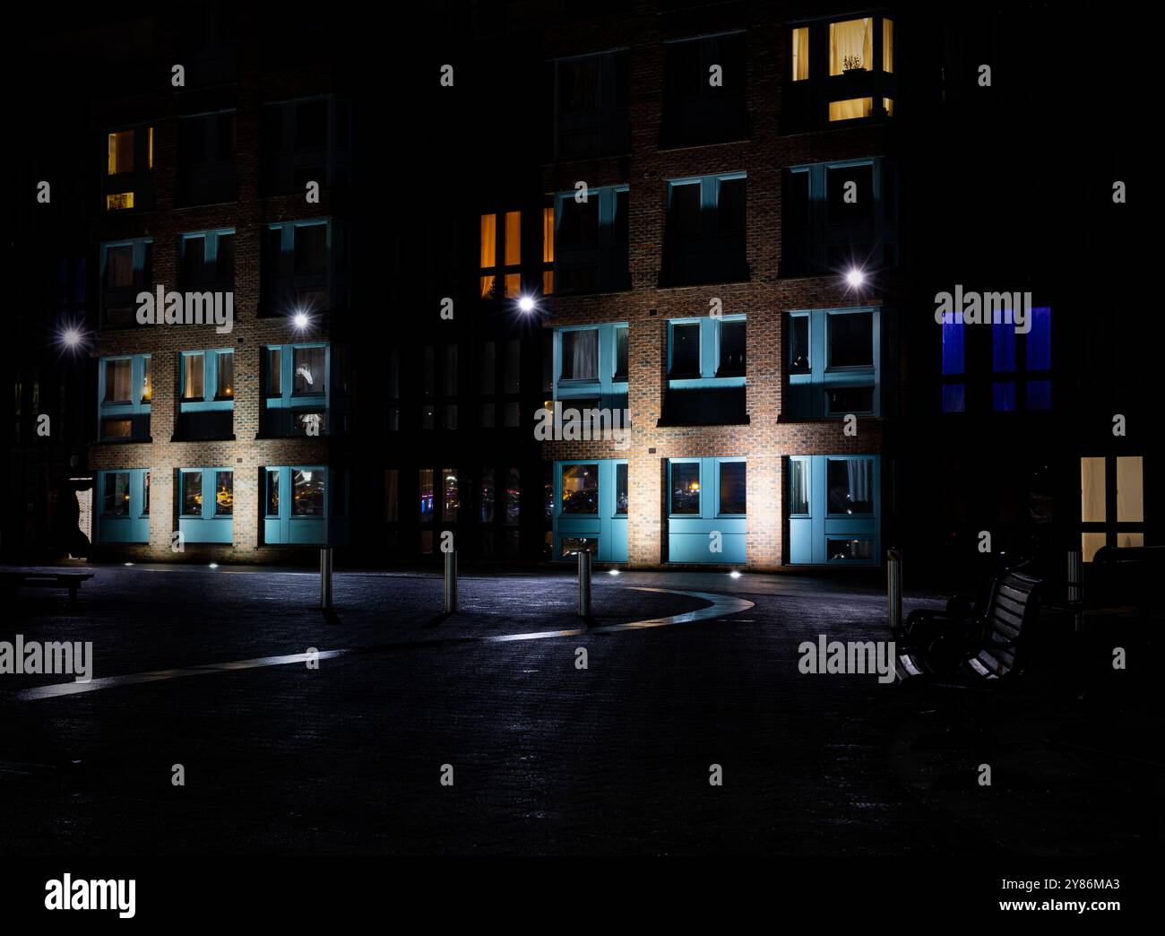 Park benches outside illuminated apartments at the historic docks at ...