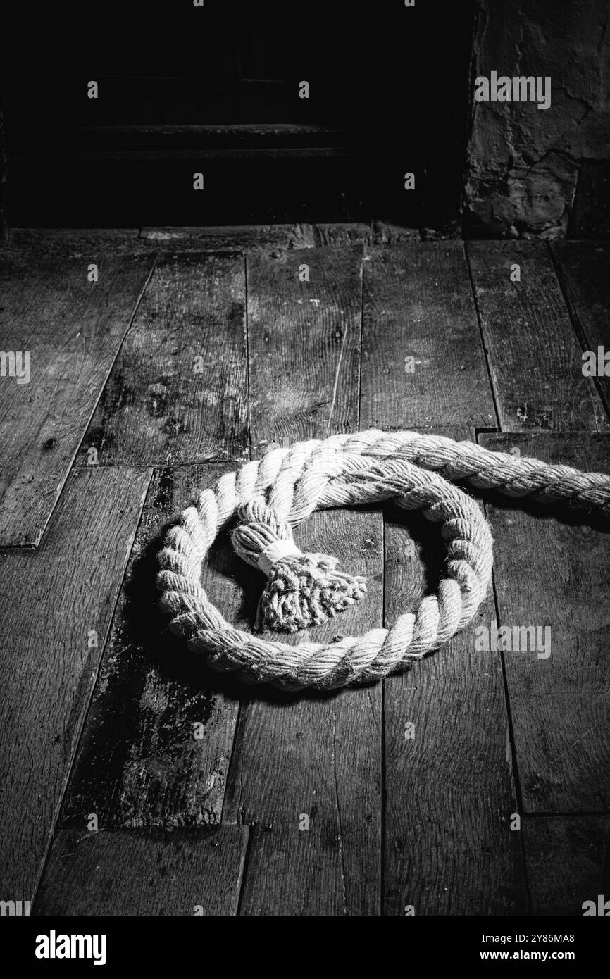 A coil of rope on oak floorboards in a medieval moated manor house ...