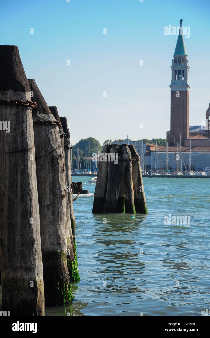 Tranquil Venice canals with wooden posts and historical buildings under ...