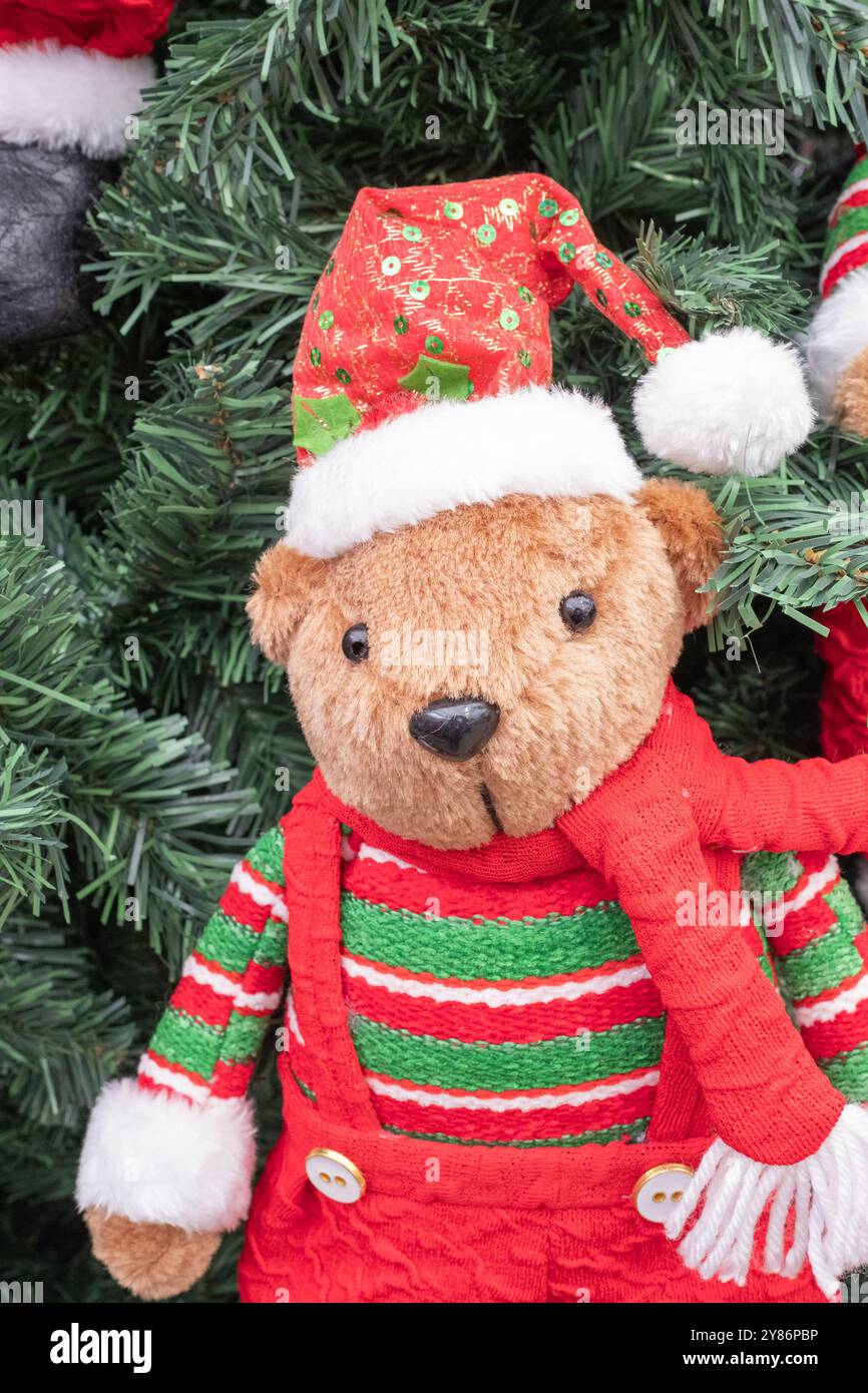 Cute teddy bear wearing a Santa hats hanging on a Christmas tree ...