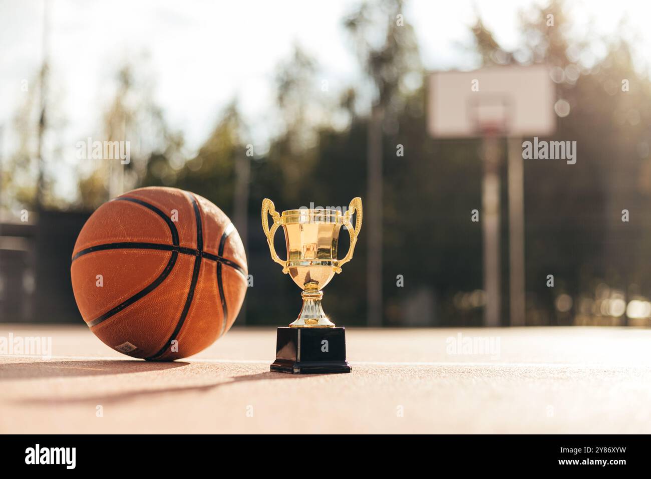 Basketball ball and golden cup on rubber playground close up, street ...