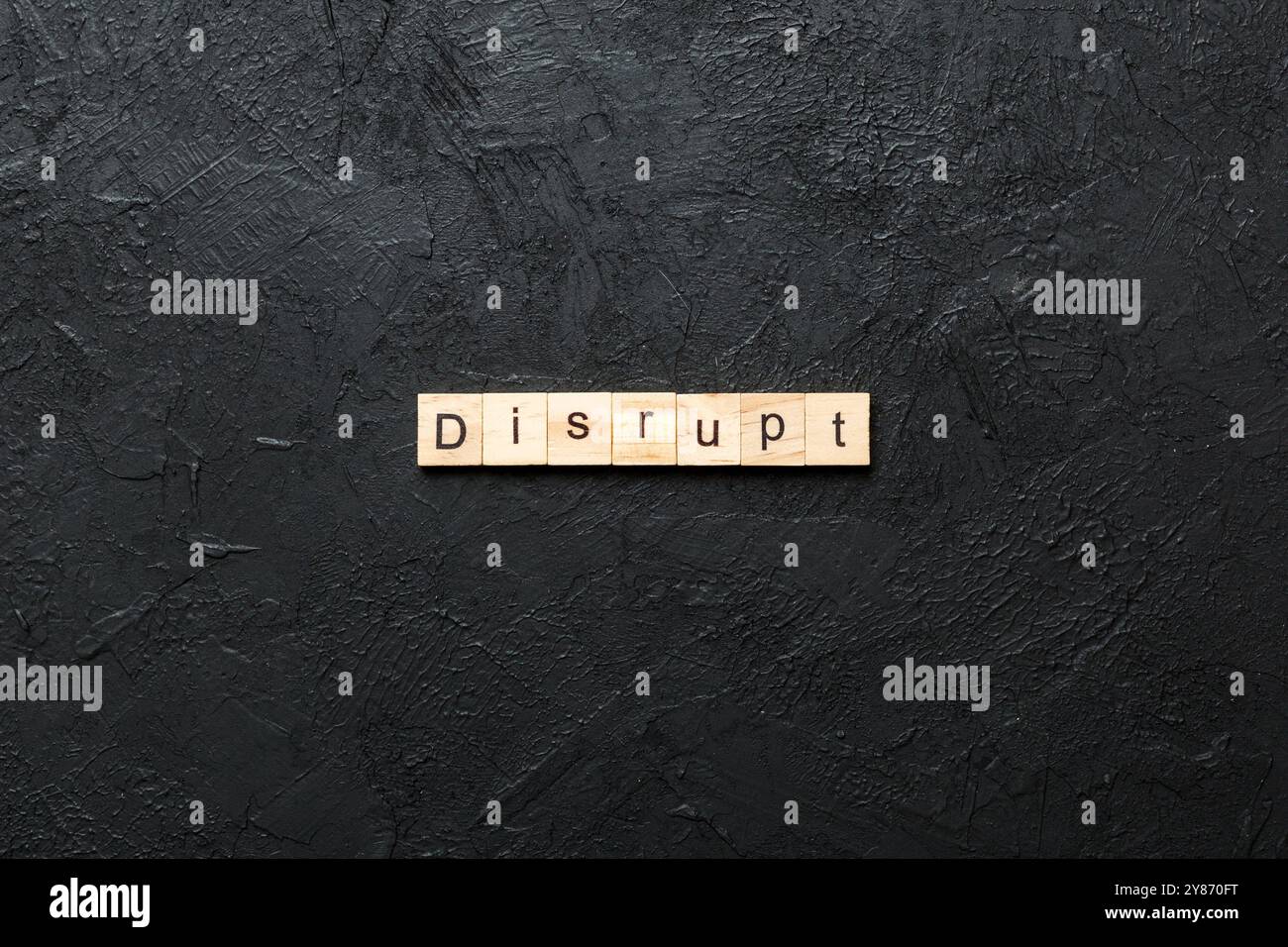 DISRUPT word written on wood block. DISRUPT text on cement table for ...