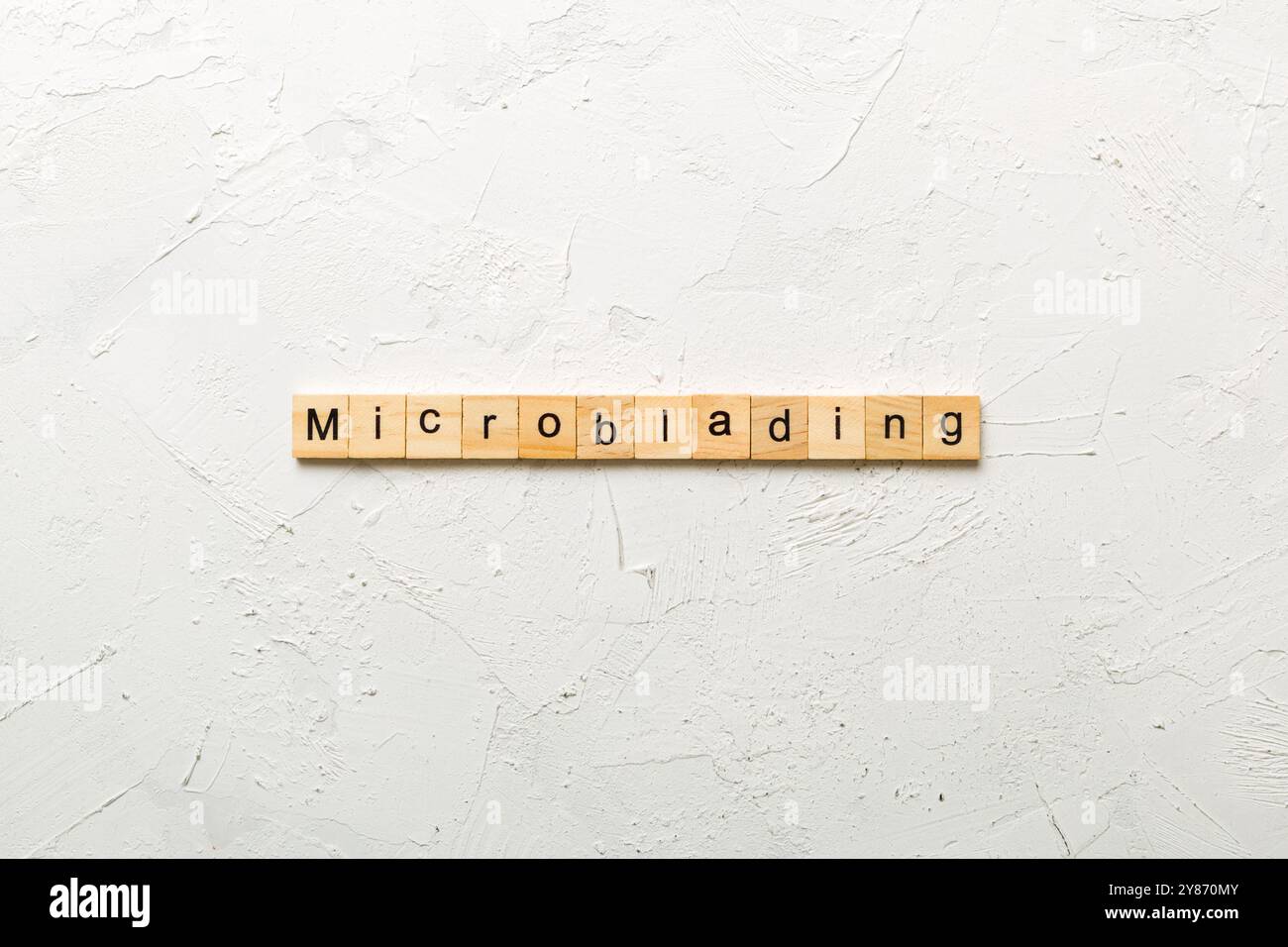 Microblading word written on wood block. Microblading text on cement table for your desing ...