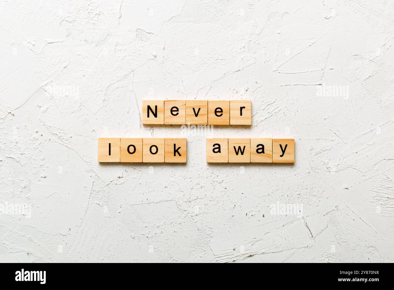 Never look away word written on wood block. Never look away text on ...