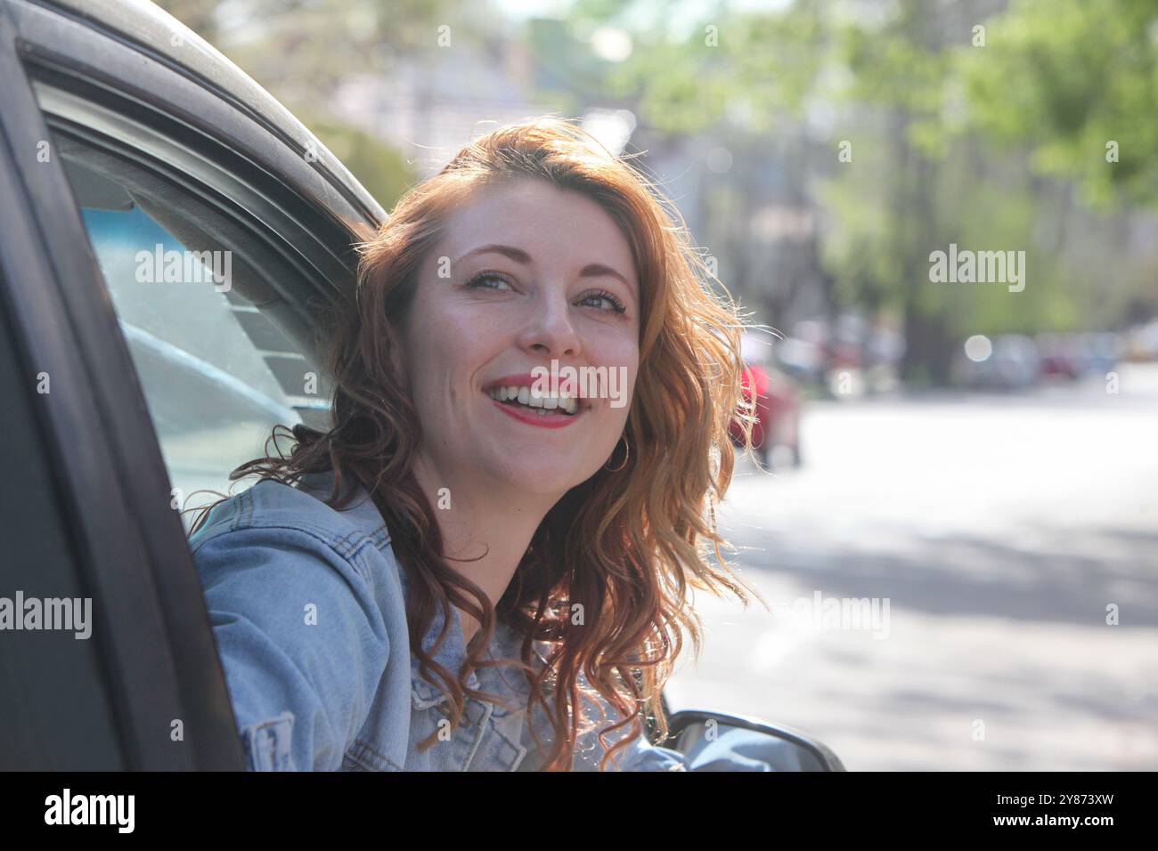 closeup portrait of pretty cheerful woman sticking her head out the car ...