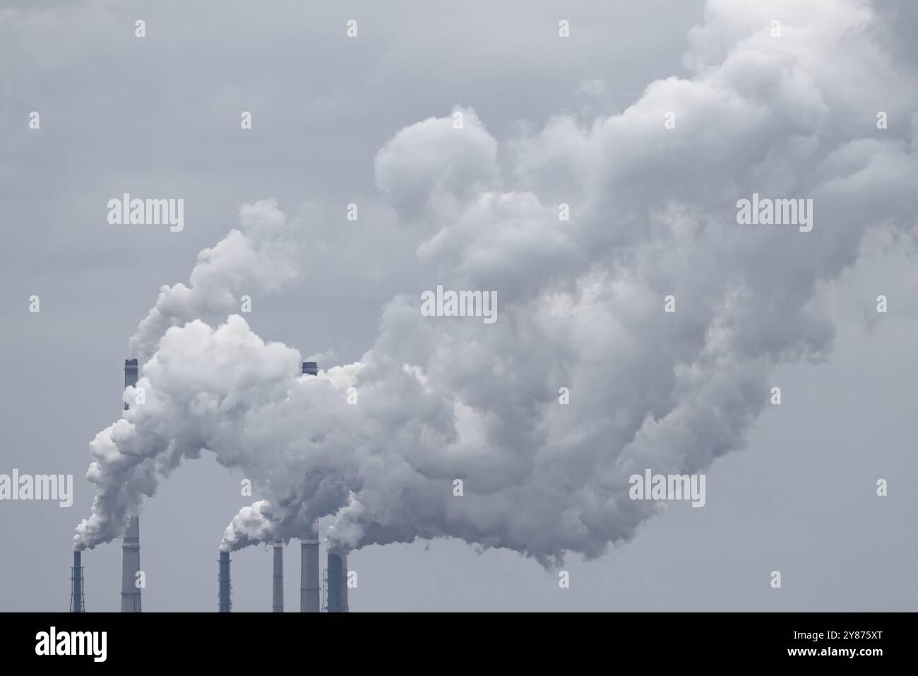 Several chimneys of a coal power station release big clouds of smoke ...