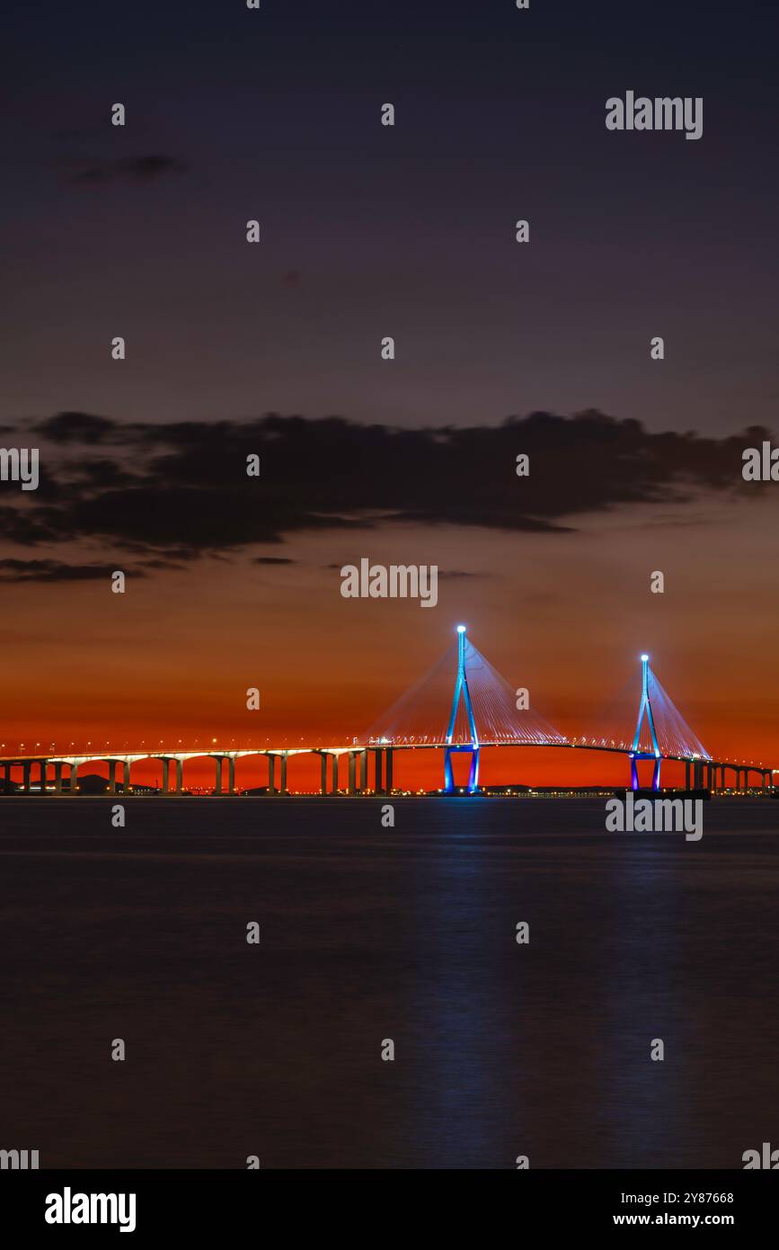 A dusk view of Incheon Bridge, illuminated with blue lights reflecting ...