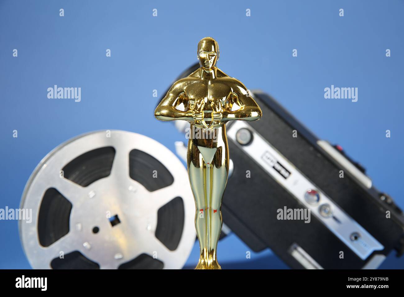 Golden Oscar award, video camera and film reel on light blue background ...