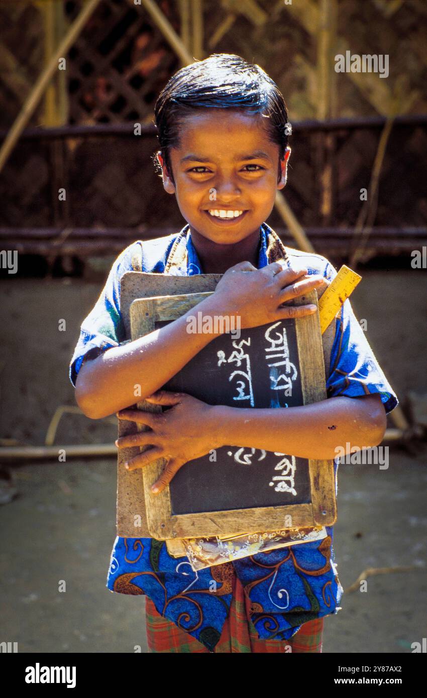 Bangladesh, Saturia, boy with chalk and slate in front of her primary ...