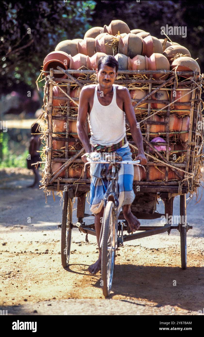 Bangladesh, Sadarghat, rickshaw driver is transporting pottery bowls ...