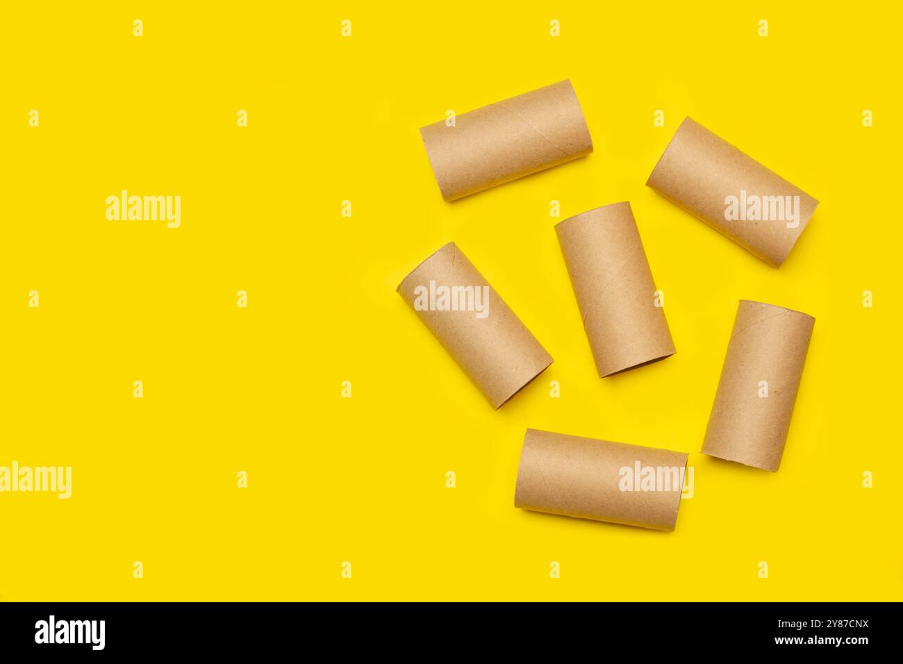 Cardboard toilet paper rolls without paper on a yellow background with ...