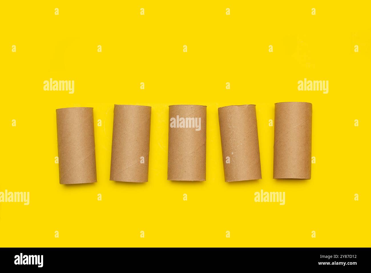 Cardboard toilet paper rolls without paper on a yellow background with ...