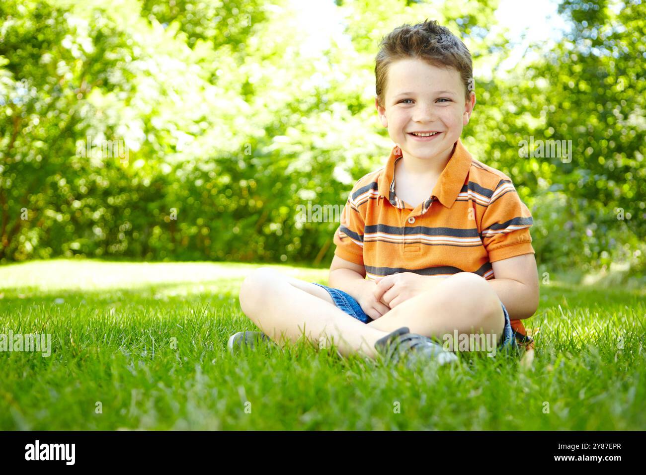 Boy, child and outdoor portrait on grass, forest adventure and ...