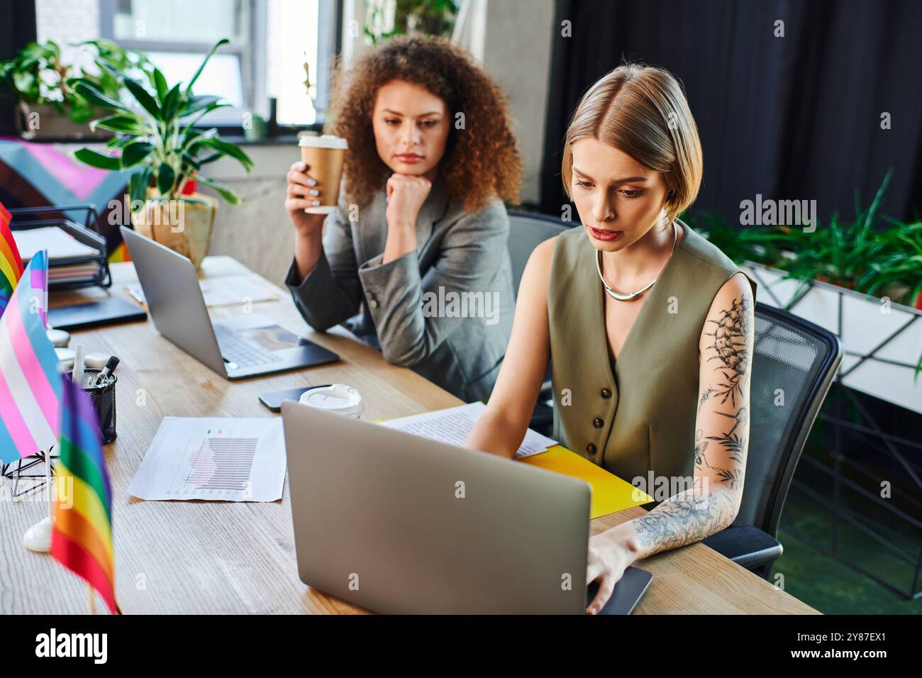 In a lively workspace, two colleagues engage in a focused discussion ...