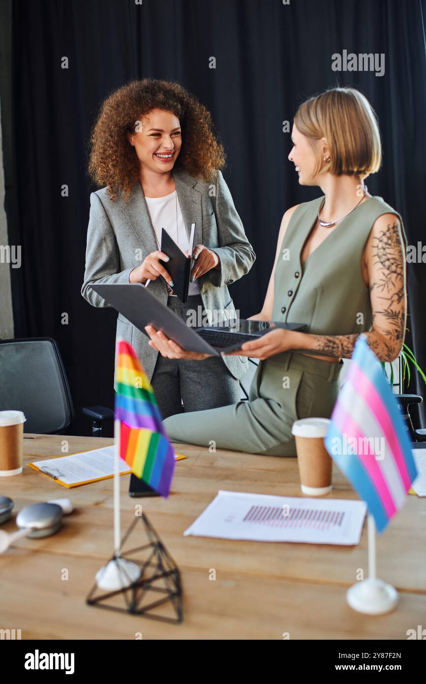 Two coworkers share a joyful moment while celebrating diversity and ...