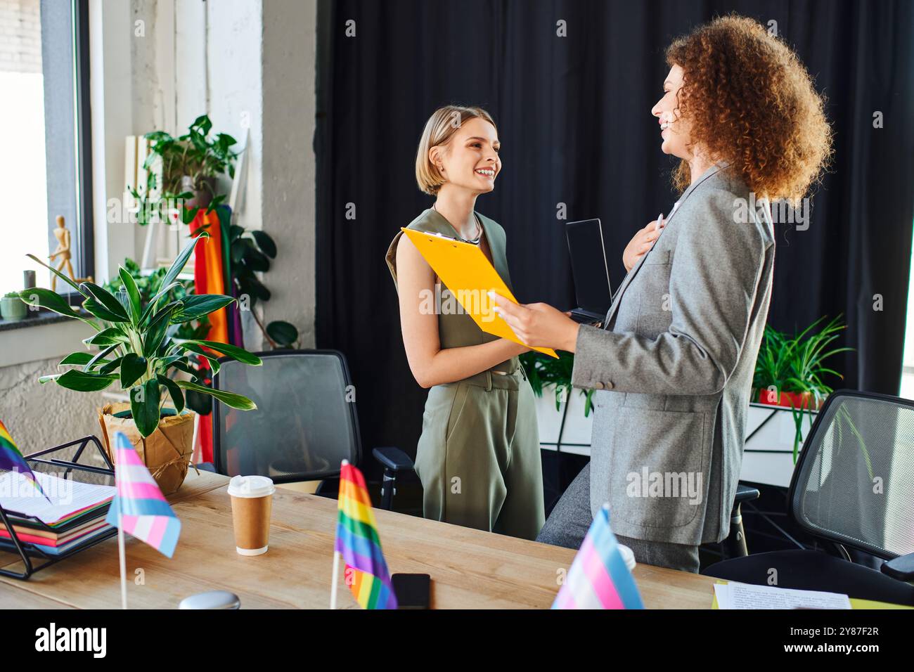 Two coworkers share a joyful moment in their inclusive office ...