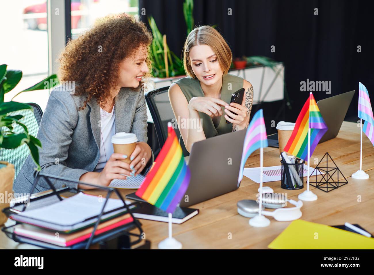 Two coworkers share ideas over coffee while celebrating diversity in ...