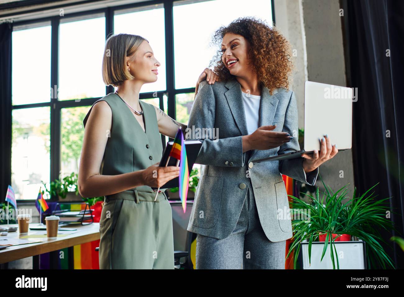Two coworkers share a joyful moment in a vibrant office, creating ...