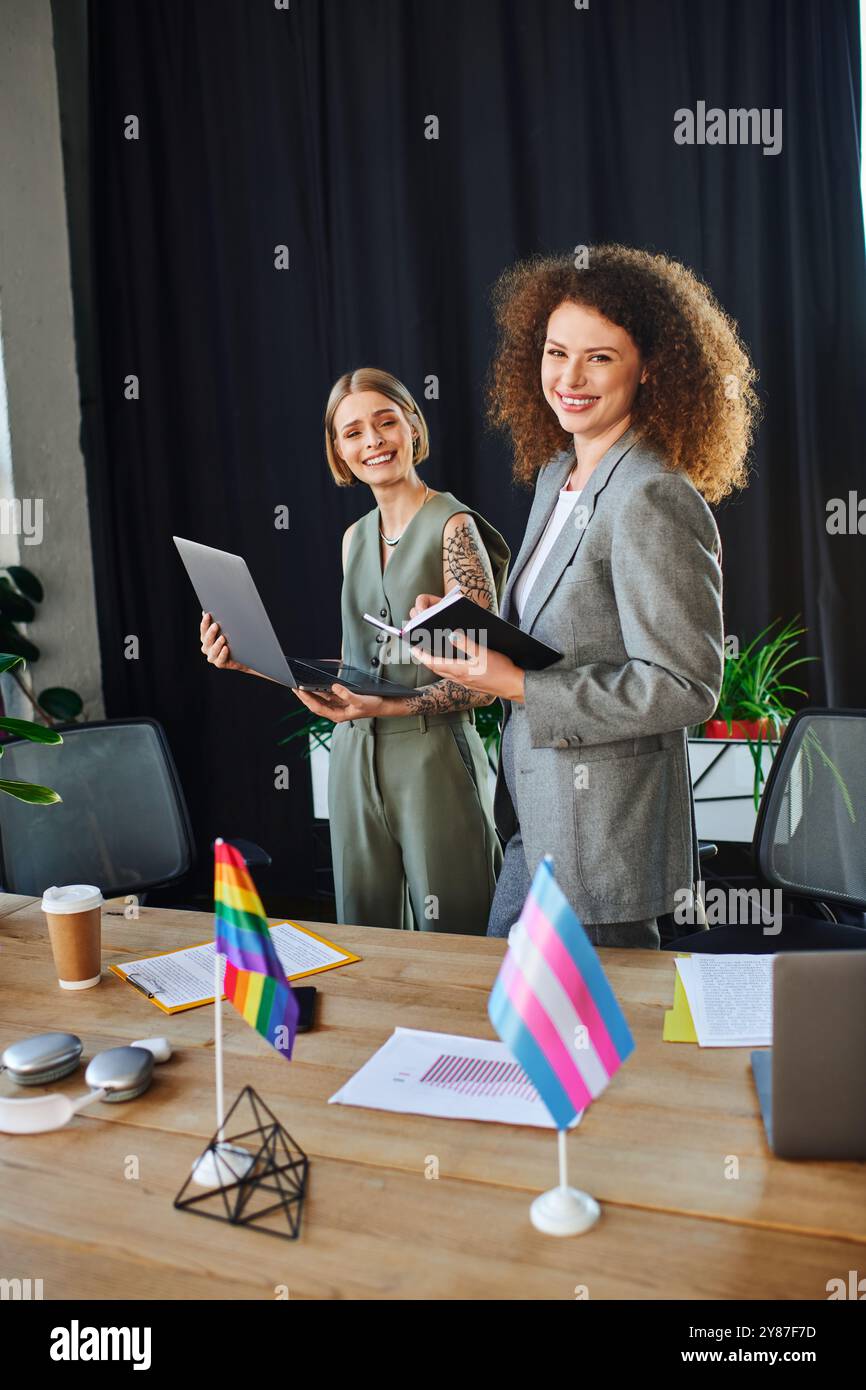 Two happy coworkers celebrate inclusivity while working in a lively and ...