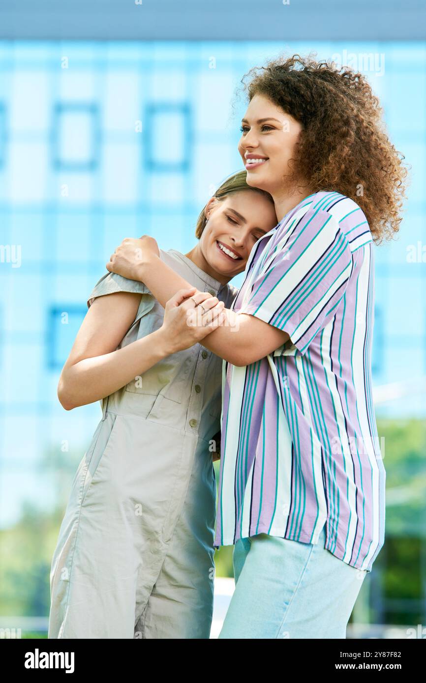 Two friends share a warm embrace, laughing and enjoying each others ...