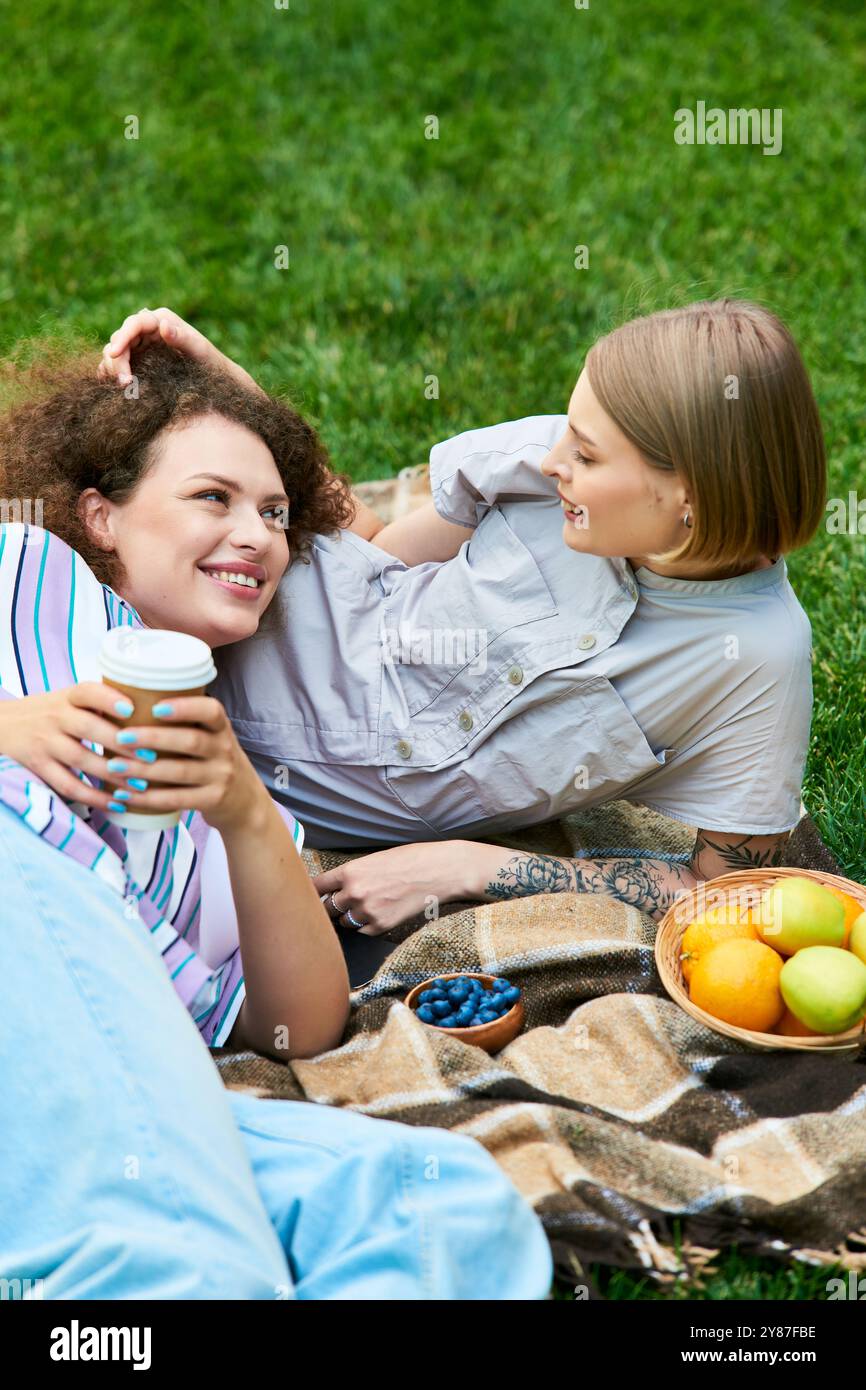 Two young women share laughter and stories while enjoying snacks on a ...
