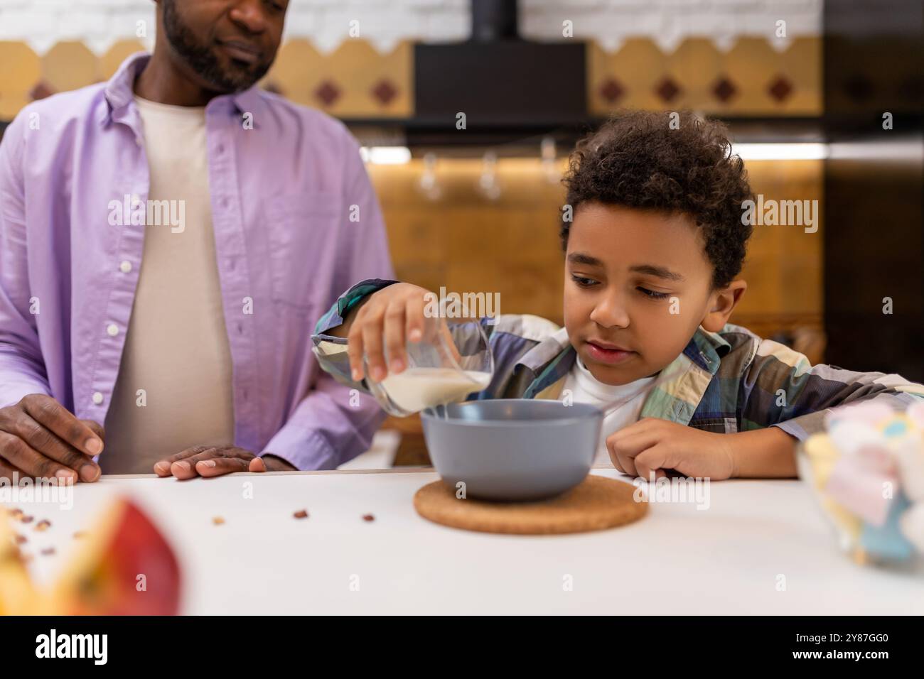 Cute african american boy eating breakfast, his dad sitting near Stock ...