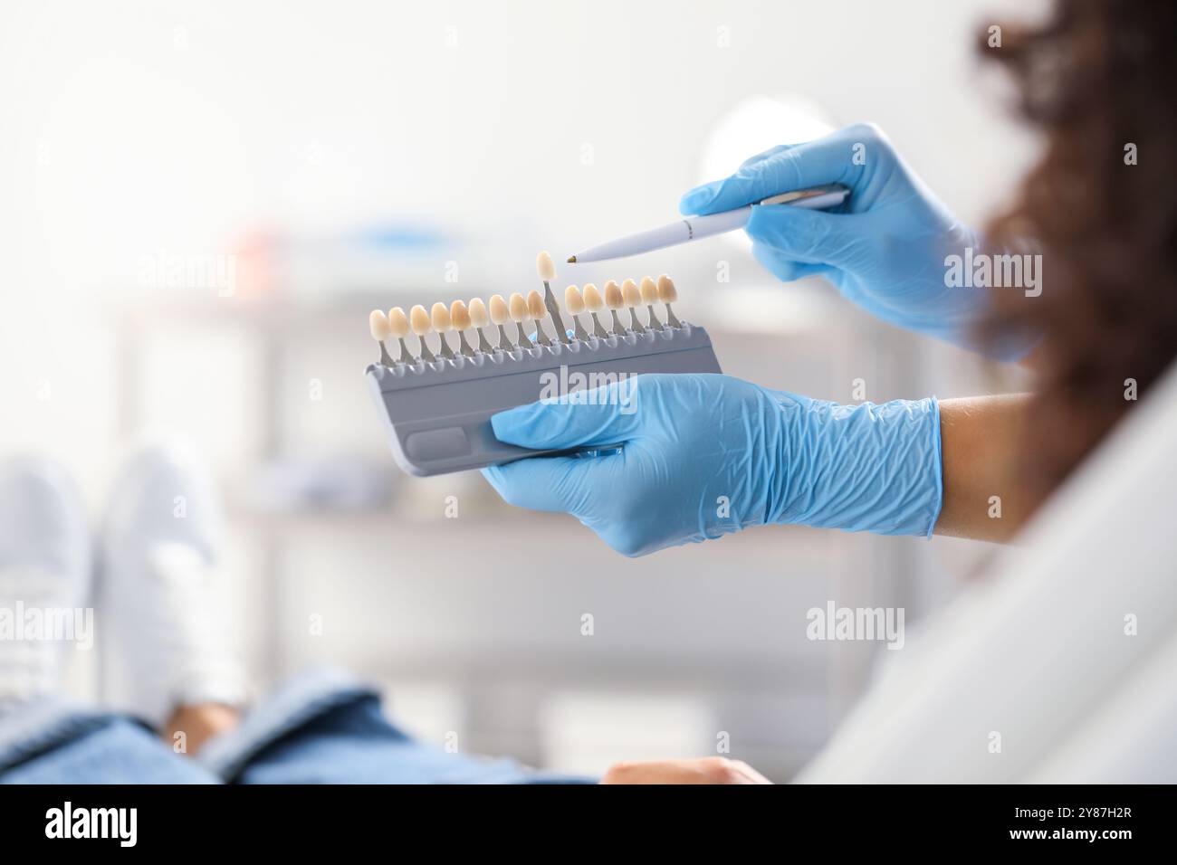 Doctor and patient choosing shade on teeth color palette in clinic ...