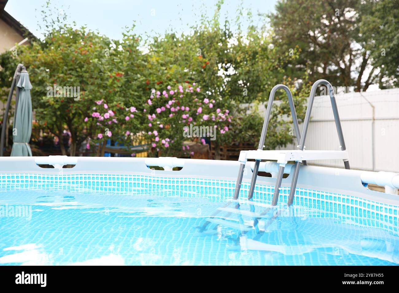 Above ground swimming pool with handrails and ladder in backyard Stock ...