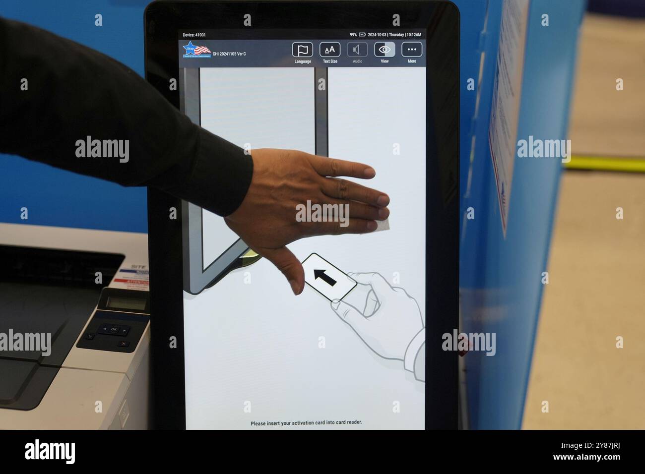 A screen on a voting machine is wiped down on the first day of early ...